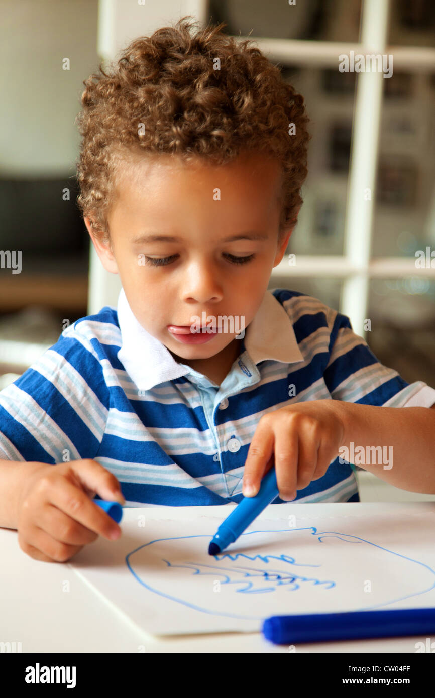 Portrait of a preschooler looking happy after finishing his homework ...