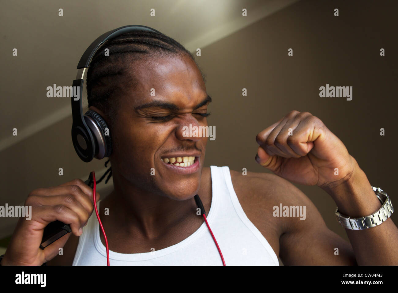Smiling man singing with headphones Stock Photo - Alamy
