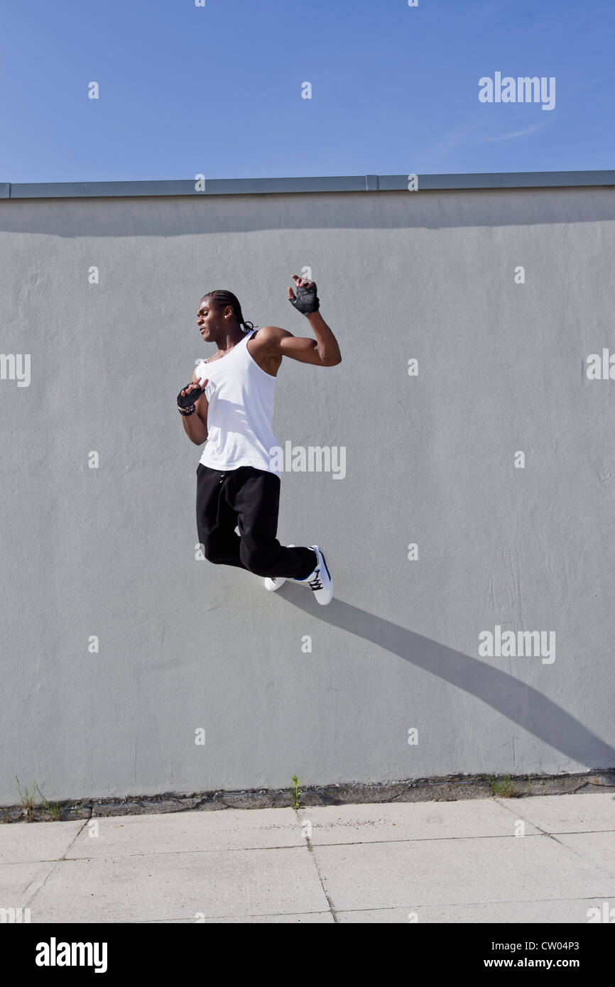 Man jumping against wall outdoors Stock Photo - Alamy