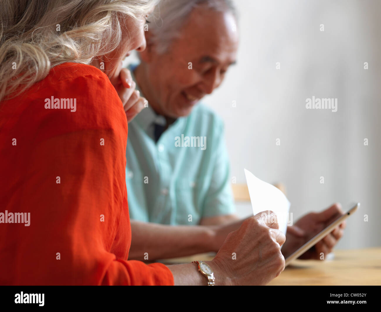 Older couple reading mail in kitchen Stock Photo - Alamy