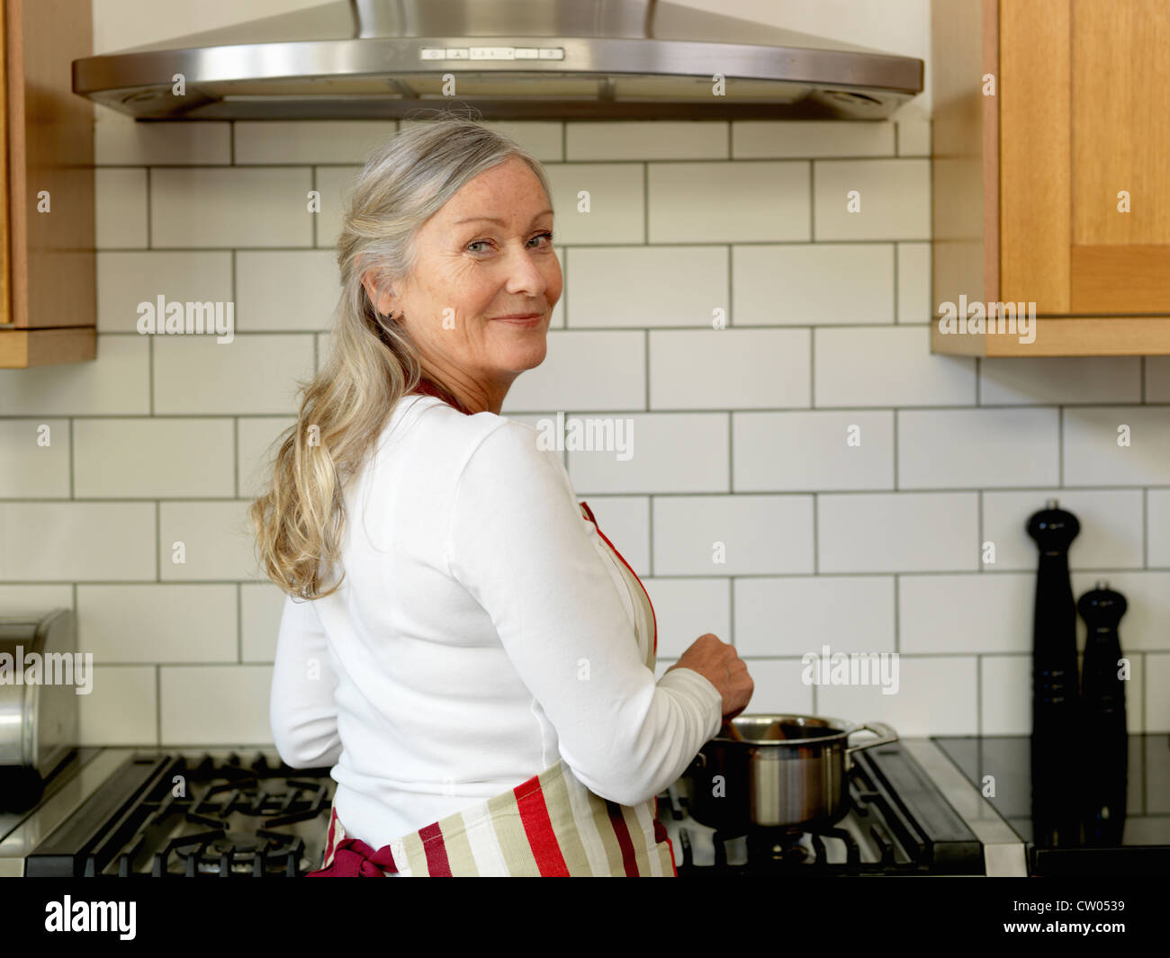 Older woman cooking in kitchen Stock Photo - Alamy