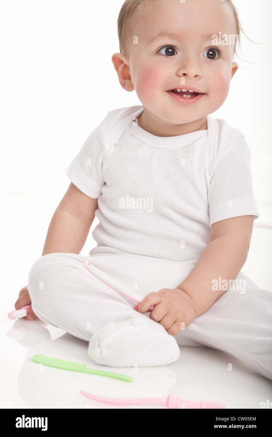 Smiling baby sitting on floor Stock Photo - Alamy