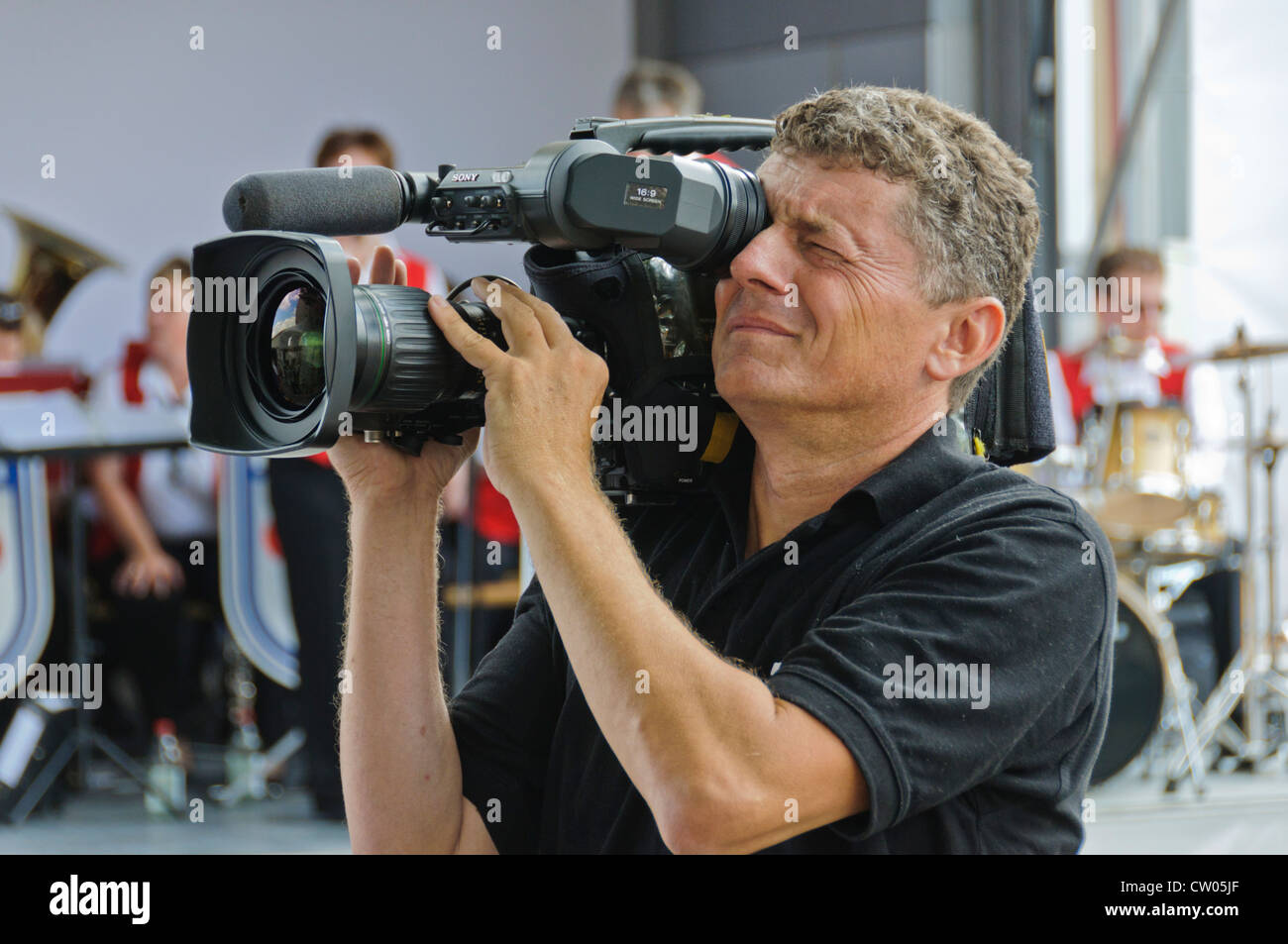 Professional TV cameraman shooting a CANON HDTV 16:9 wide screen ...