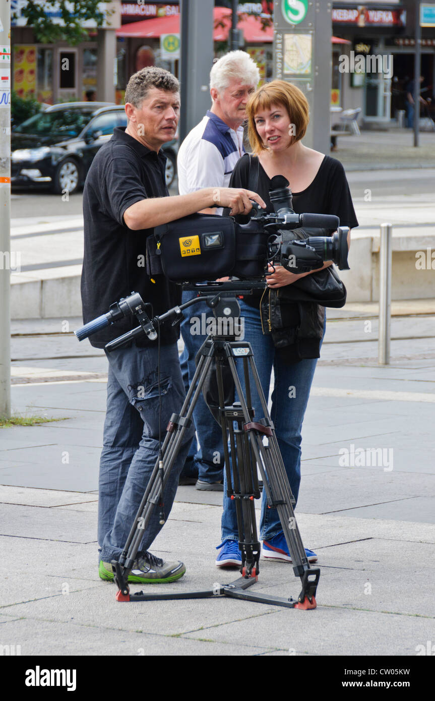 Television camera crew cameraman and female reporter with red hair ...