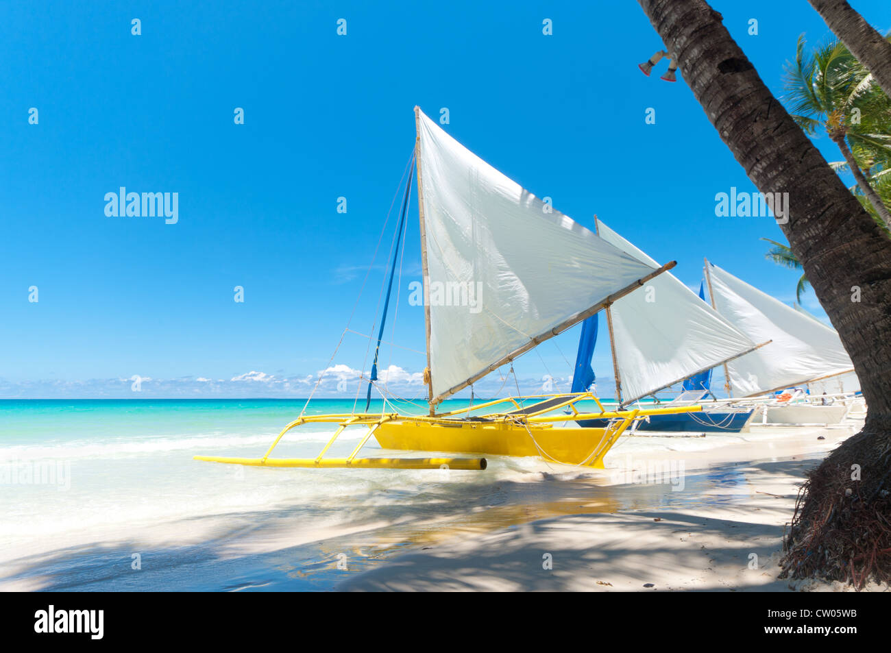 traditional paraw sailing boats on white beach on boracay island ...