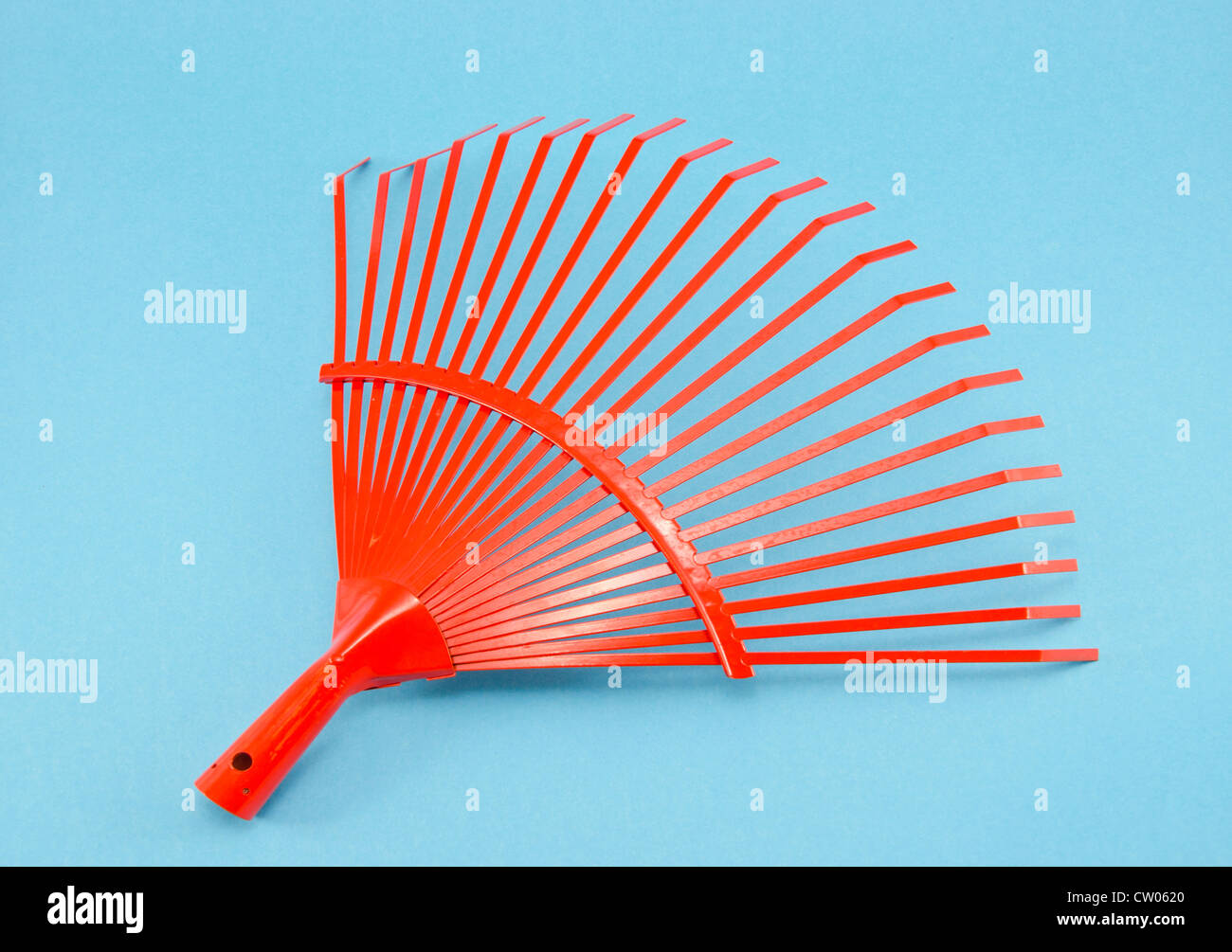 new orange garden rake on azure background Stock Photo - Alamy