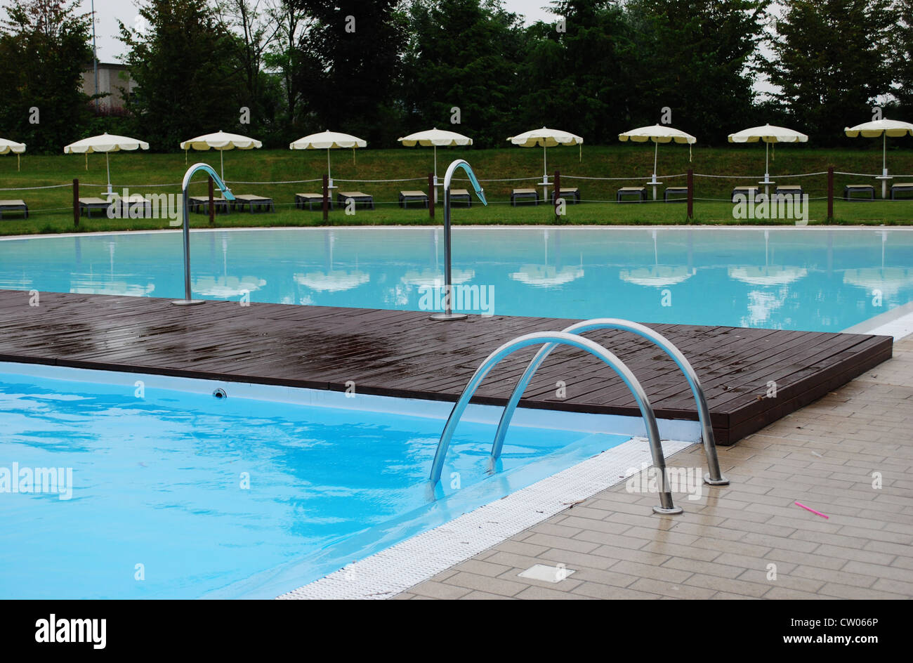 Empty outdoor swimming pool with chairs and umbrellas Stock Photo - Alamy
