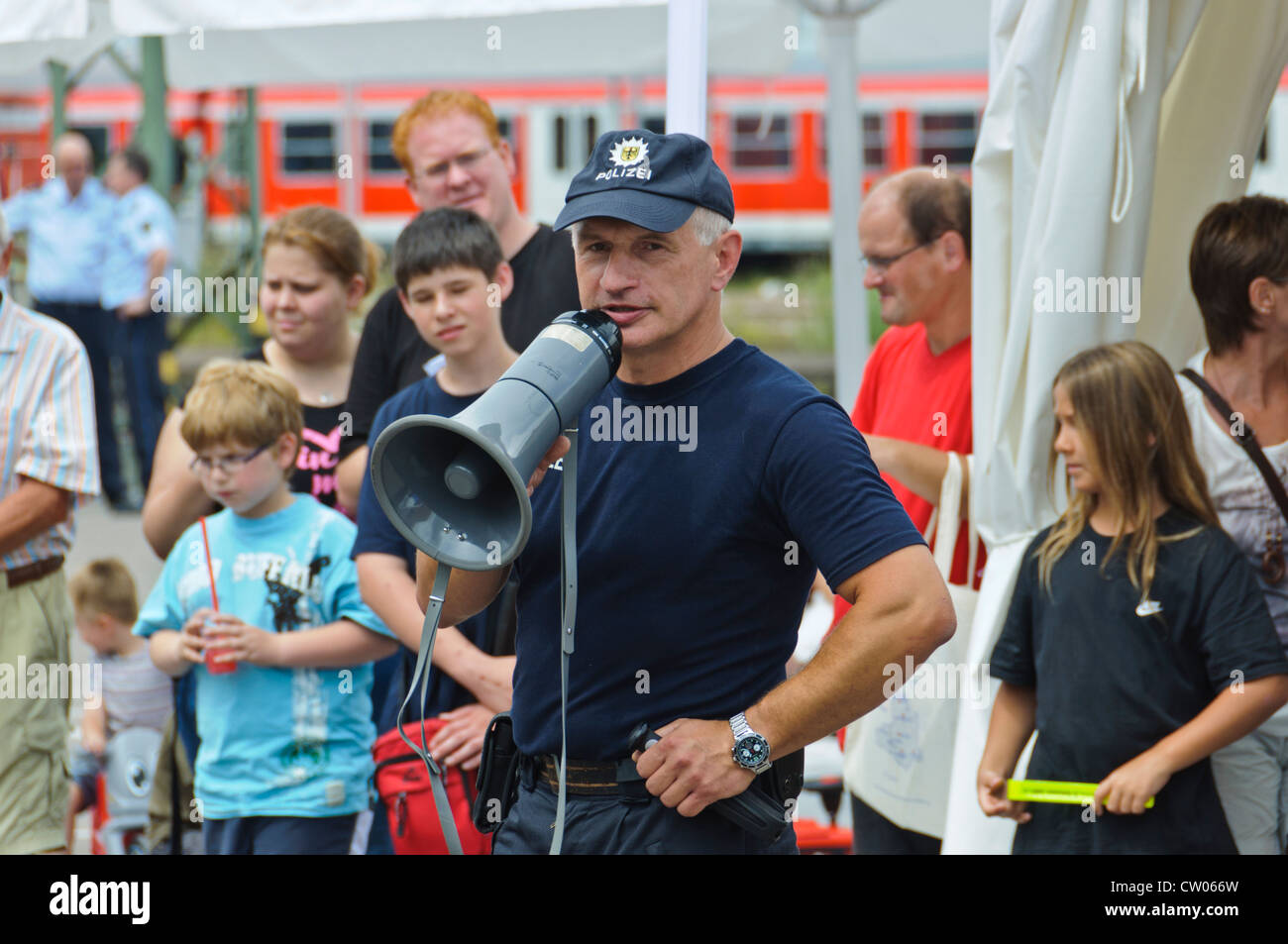 German policeman police officer wearing baseball cap talks with ...