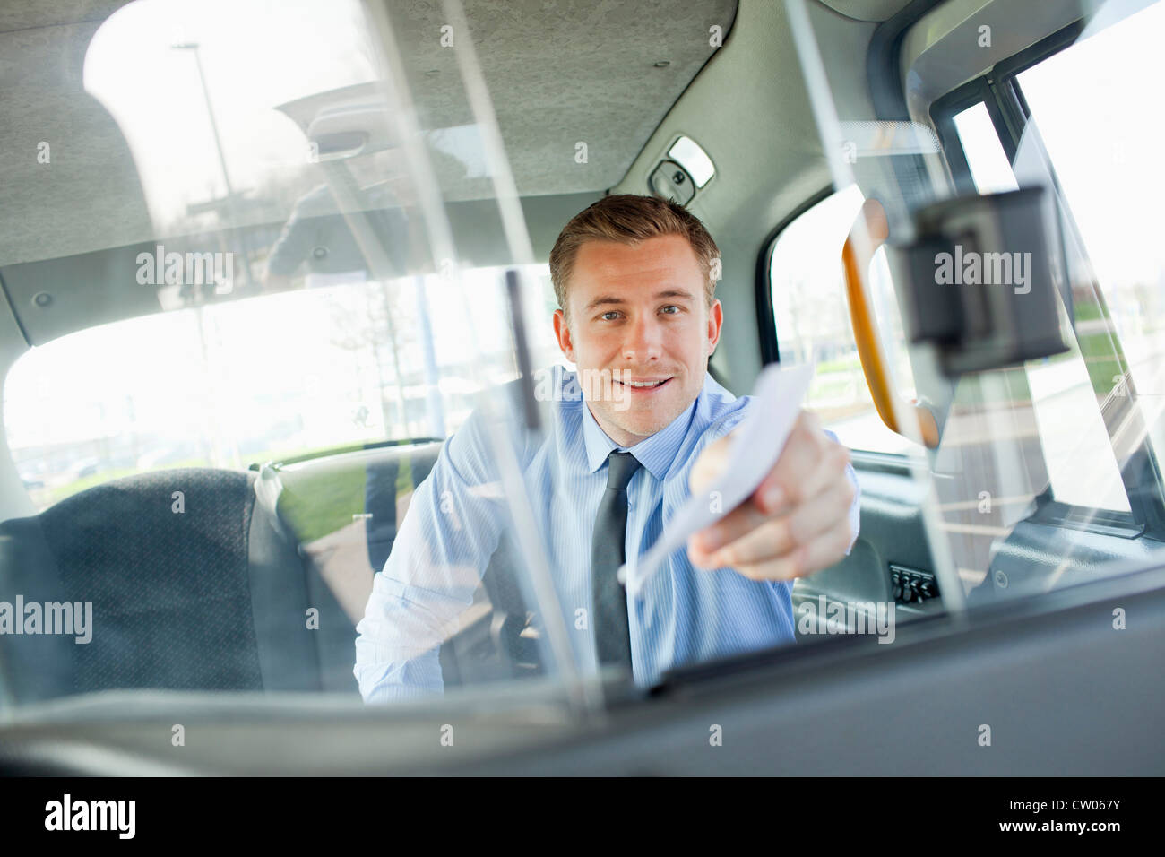 Businessman paying taxi driver Stock Photo - Alamy