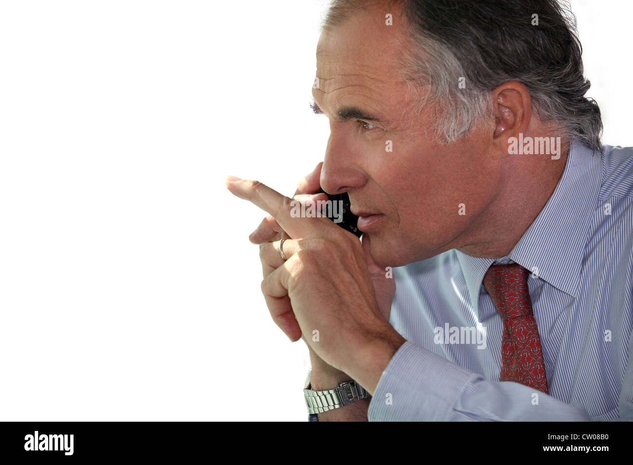 Businessman making hand gestures while talking on his mobile phone ...