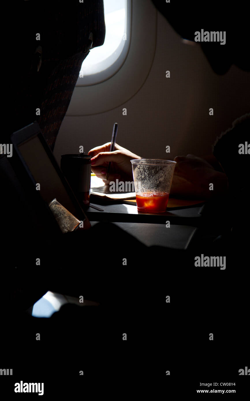 People reading and writing on a plane Stock Photo - Alamy