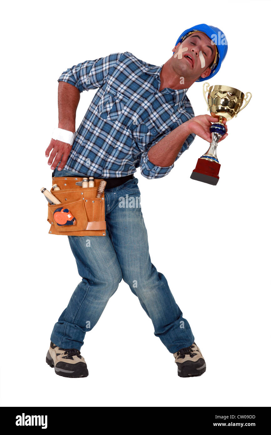 Accident prone construction worker holding a trophy Stock Photo - Alamy