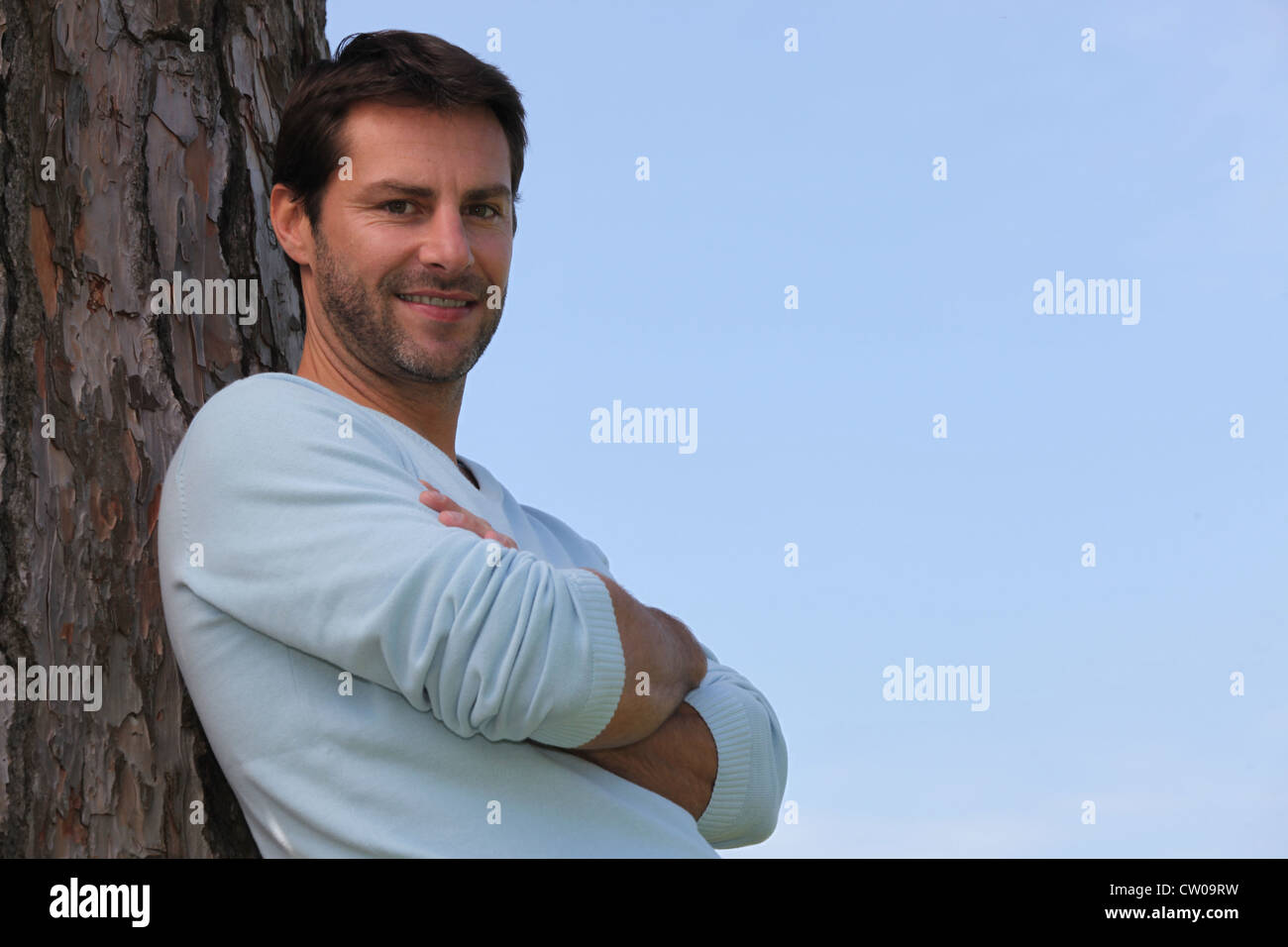 Man leaning against a tree Stock Photo - Alamy