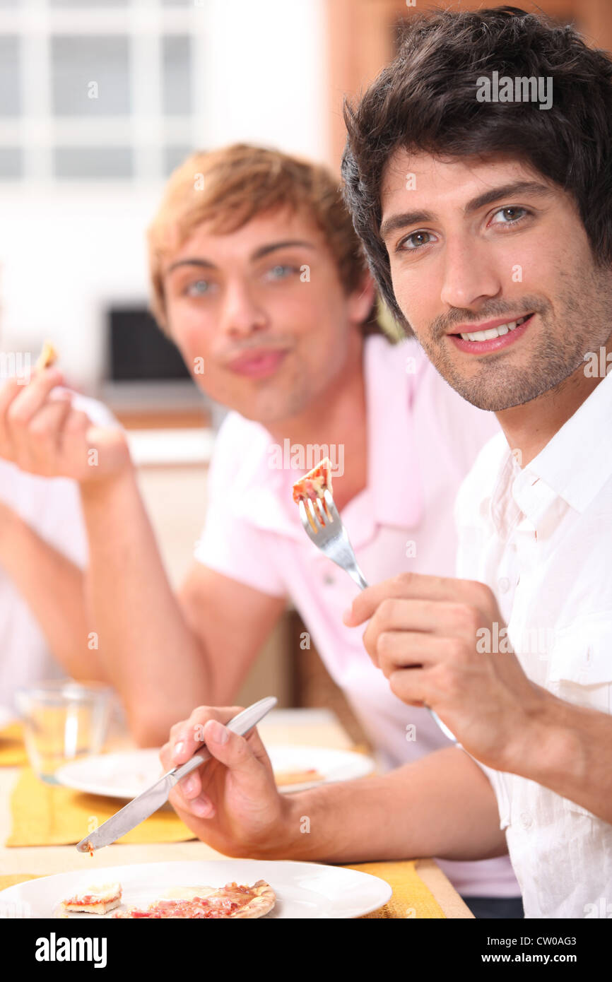Two young men eating a meal Stock Photo - Alamy