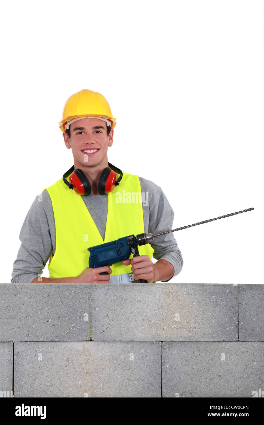 Man using drill with long bit Stock Photo - Alamy
