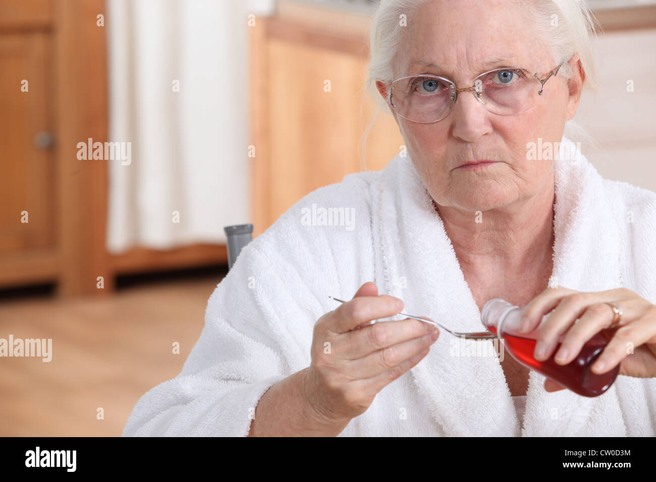 Elderly lady taking medication in kitchen Stock Photo - Alamy