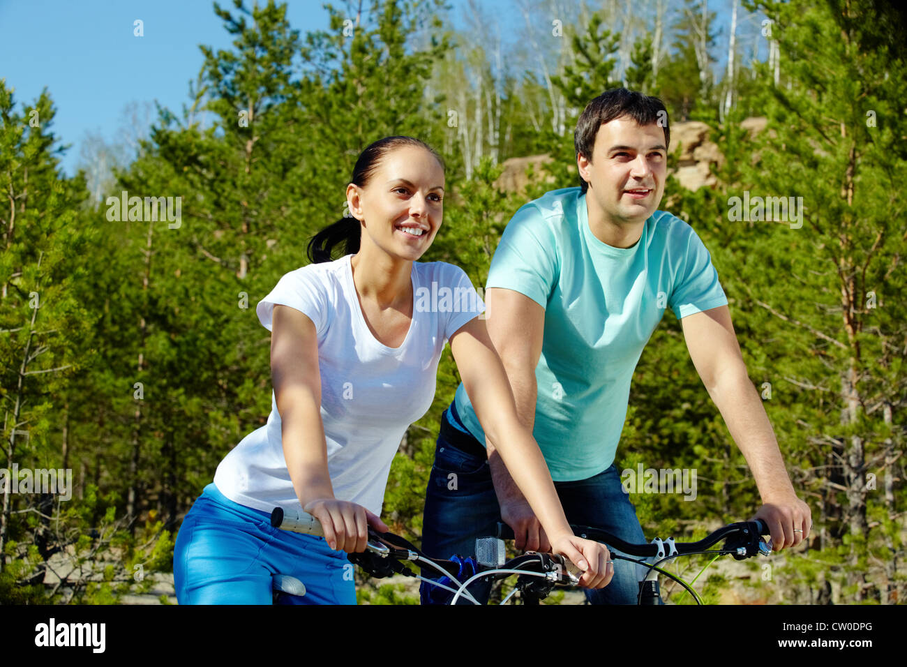 Portrait of two young people riding on bicycles in the country Stock ...