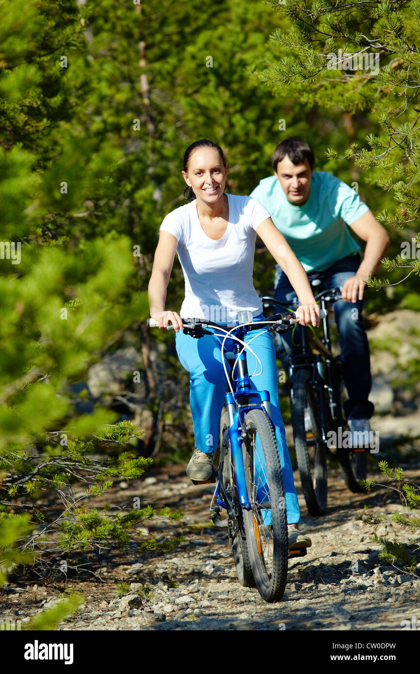 A young people riding bicycles in wood Stock Photo - Alamy