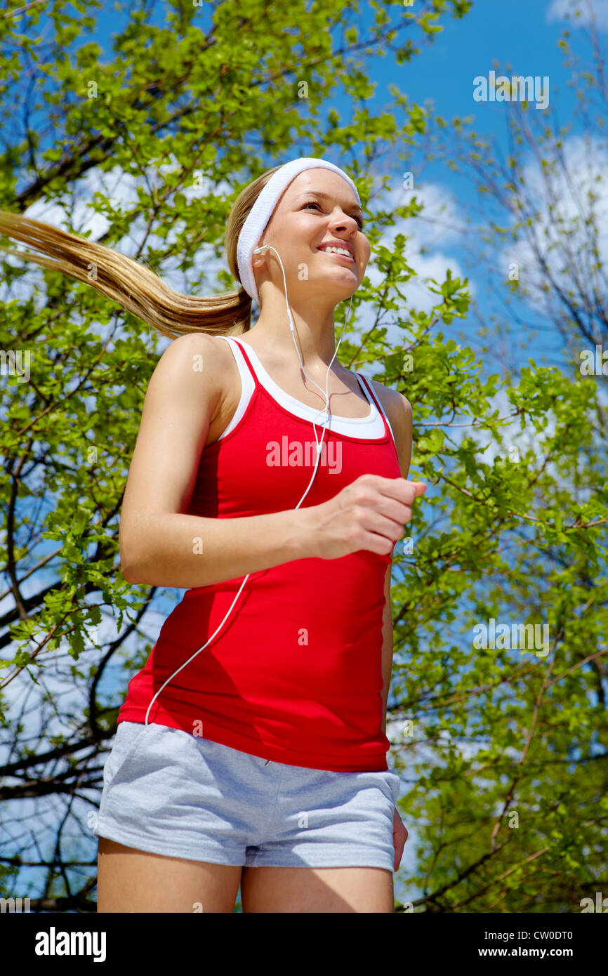 Portrait of a young woman jogging with a walkman Stock Photo - Alamy