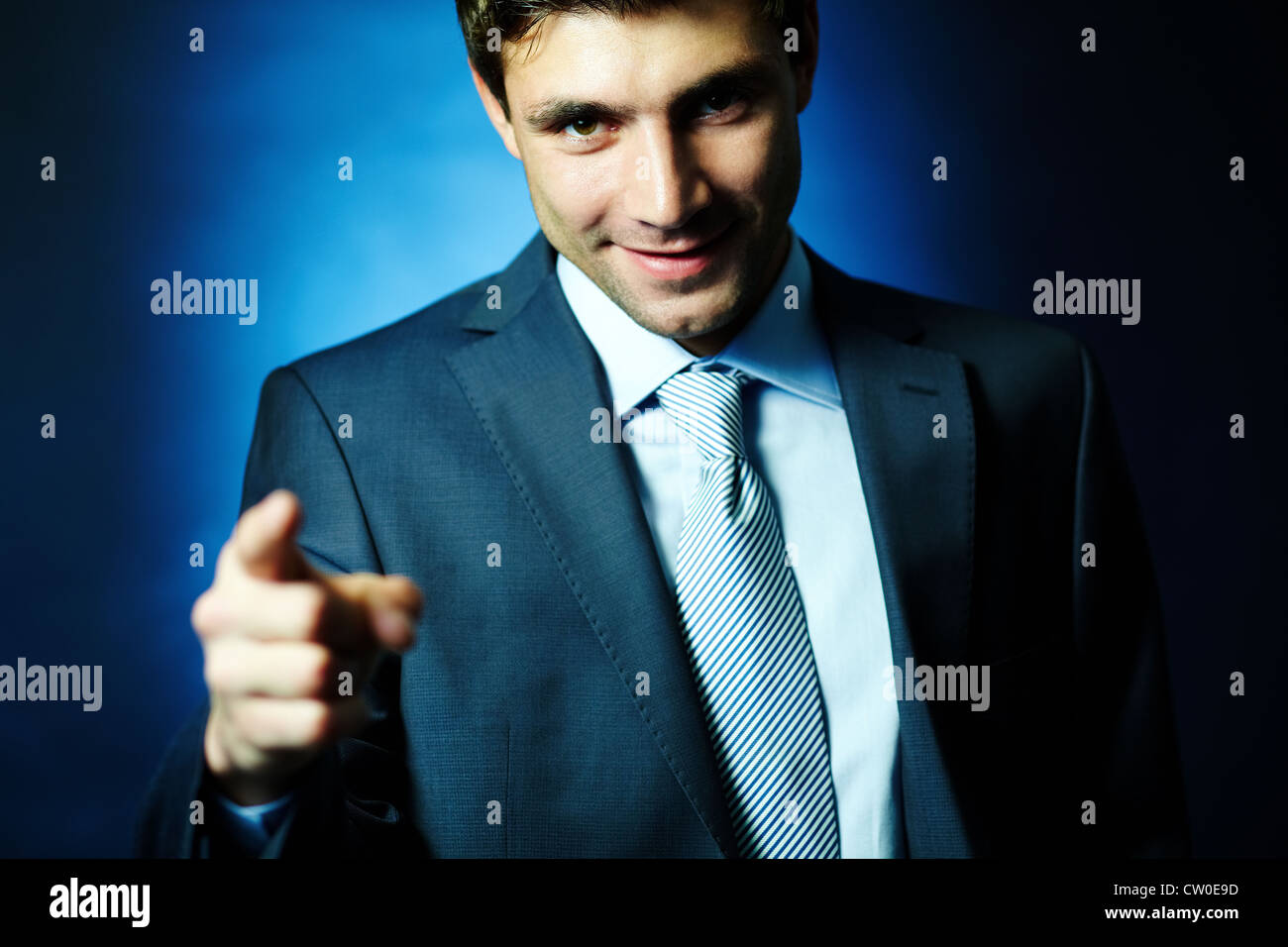 Portrait of handsome male pointing at you and looking at camera in ...