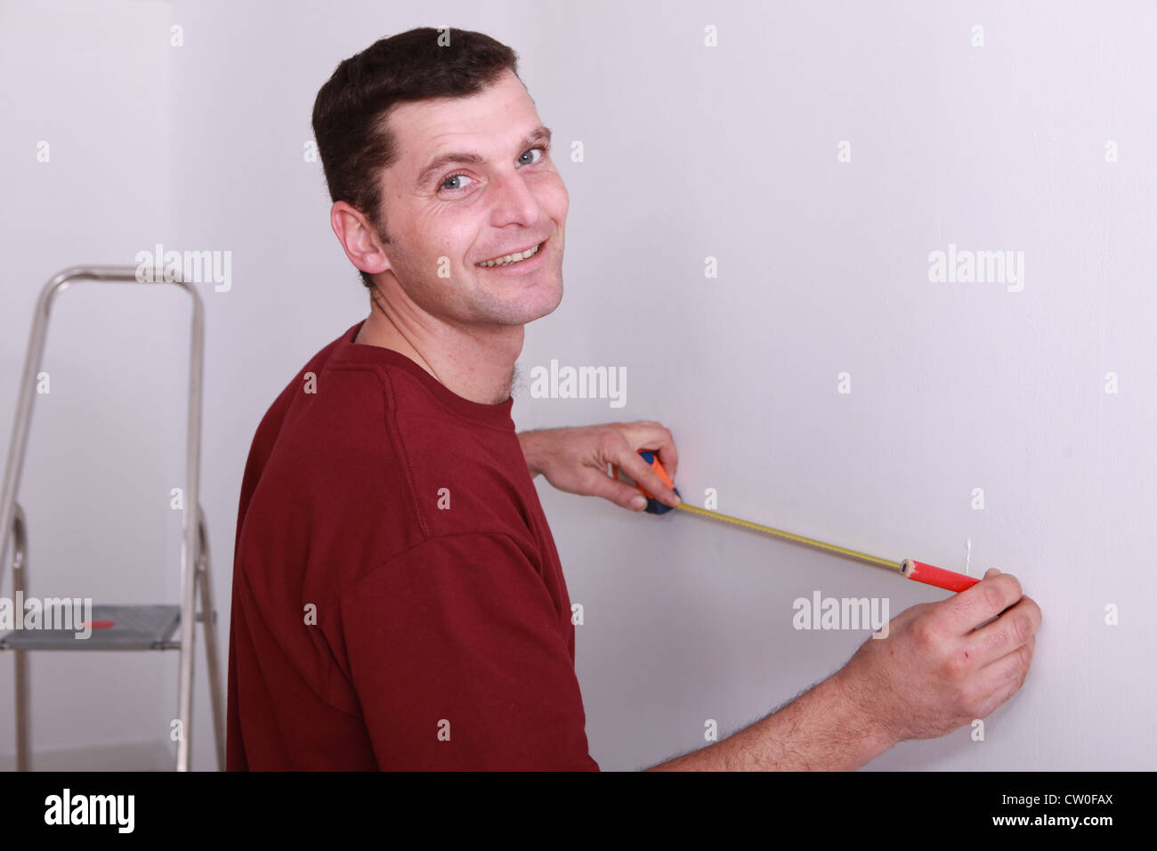 Man measuring wall Stock Photo - Alamy