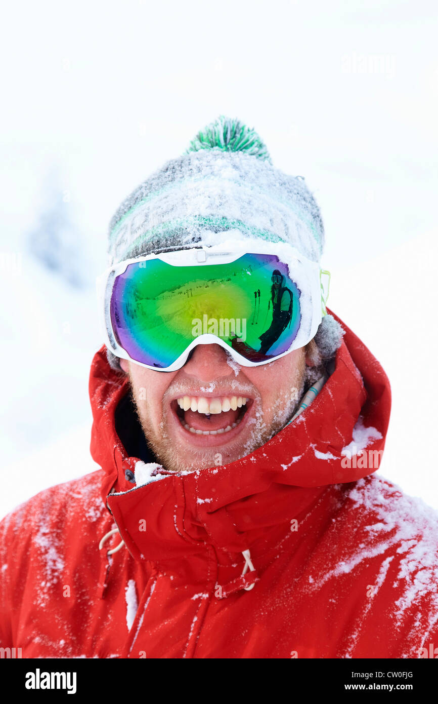 Smiling skier covered in snow Stock Photo - Alamy