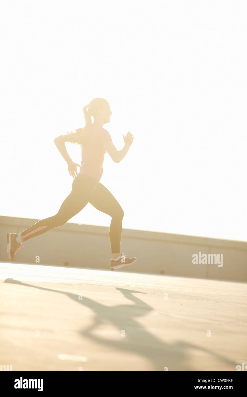Woman running on rooftop Stock Photo - Alamy