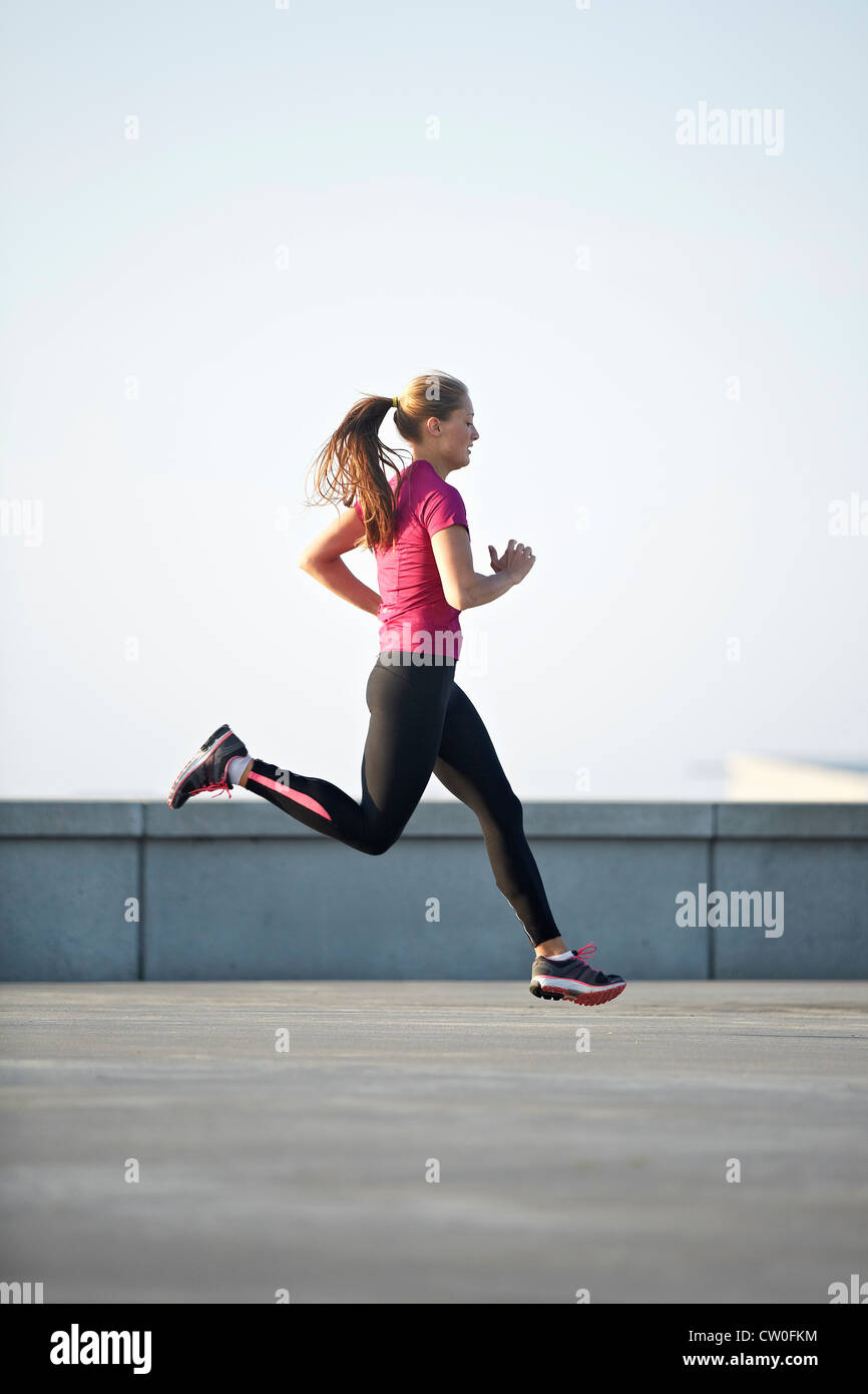 Woman running on rooftop Stock Photo - Alamy