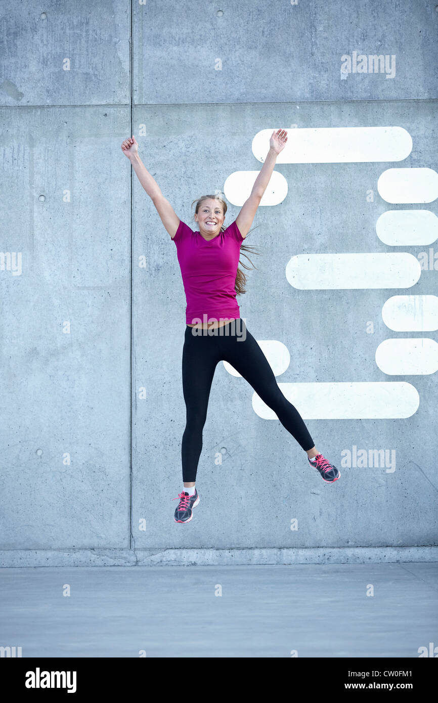 Runner jumping for joy on city street Stock Photo - Alamy