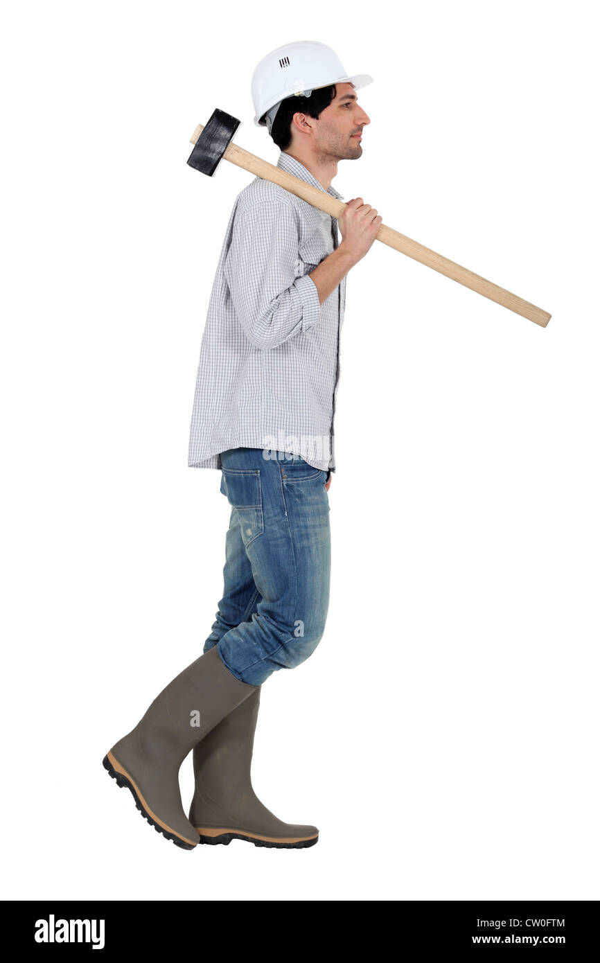 Profile of worker carrying sledge hammer Stock Photo - Alamy