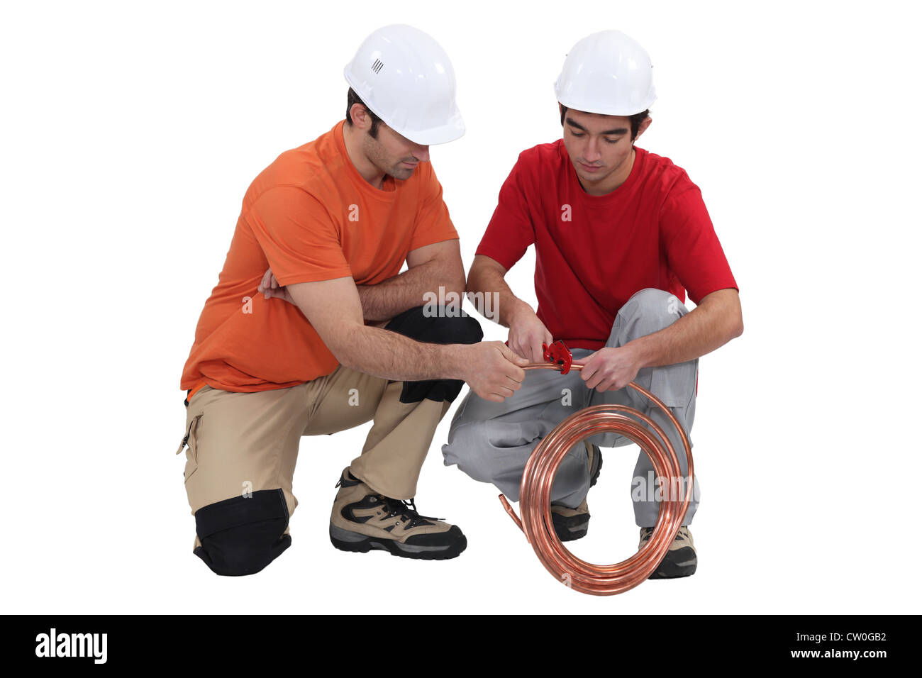 Two plumbers with copper pipe Stock Photo - Alamy