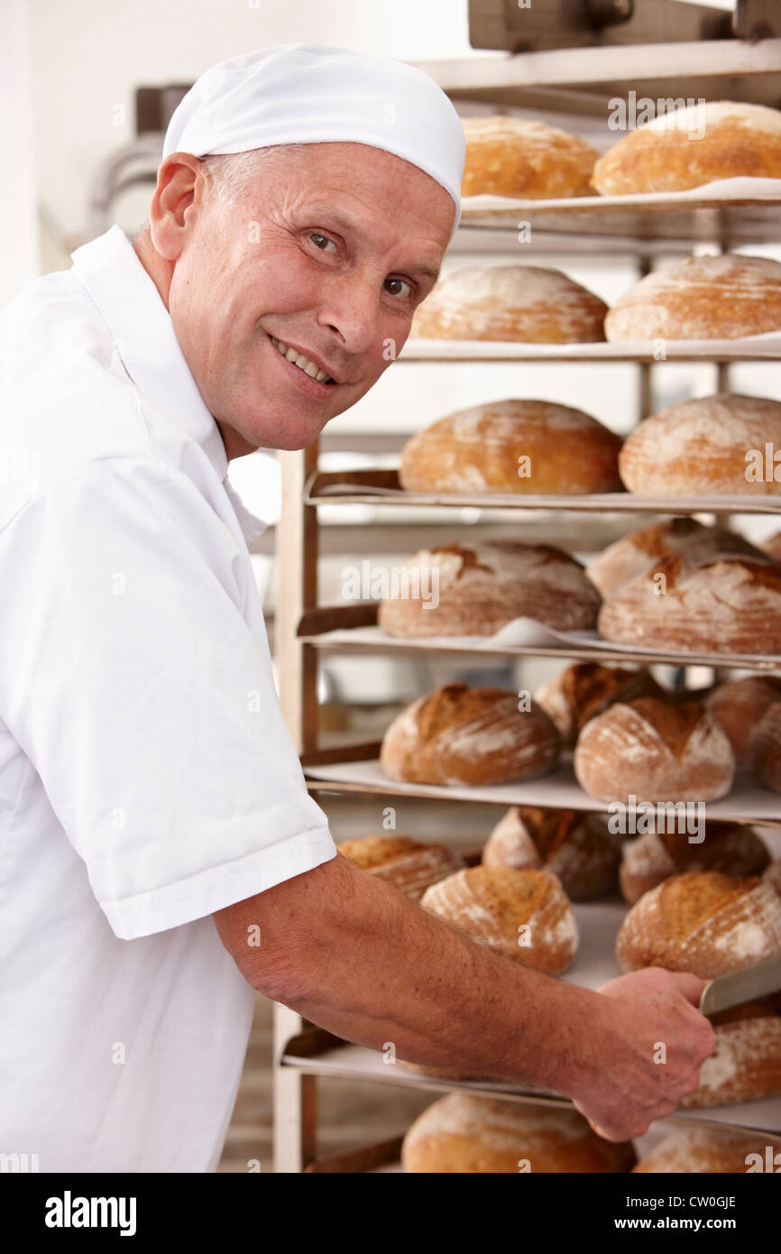Chef putting tray of bread on rack Stock Photo - Alamy