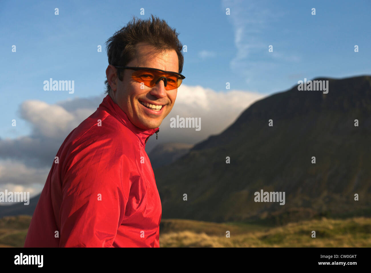 Hiker smiling in rural landscape Stock Photo - Alamy