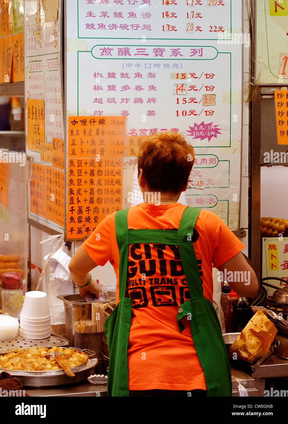 Woman hawker preparing Chinese fast food for the menu in Wan Chai, Hong ...
