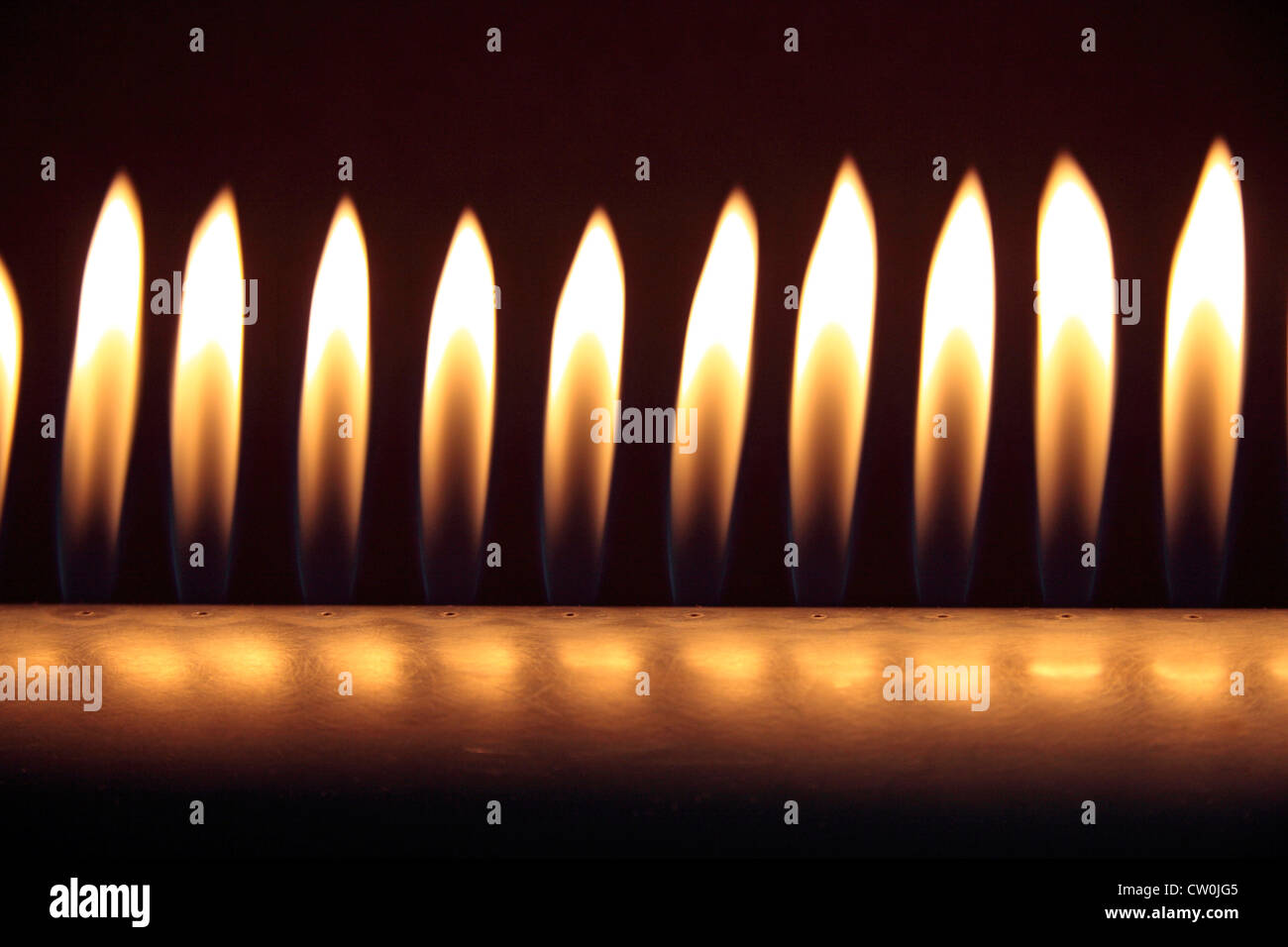 Methane gas burning bright yellow/orange in a line of single flames ...