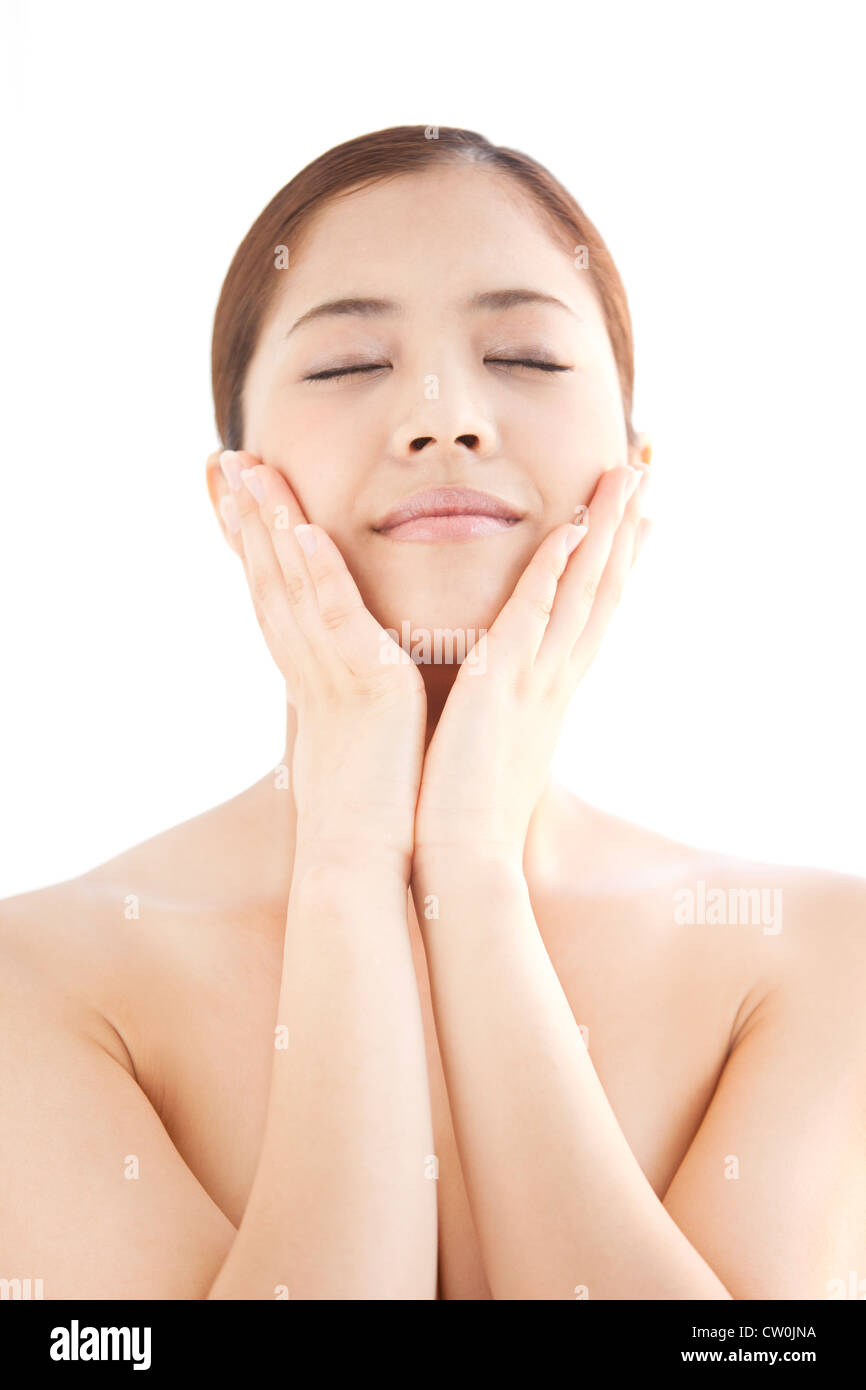 Young woman touching her cheek Stock Photo - Alamy