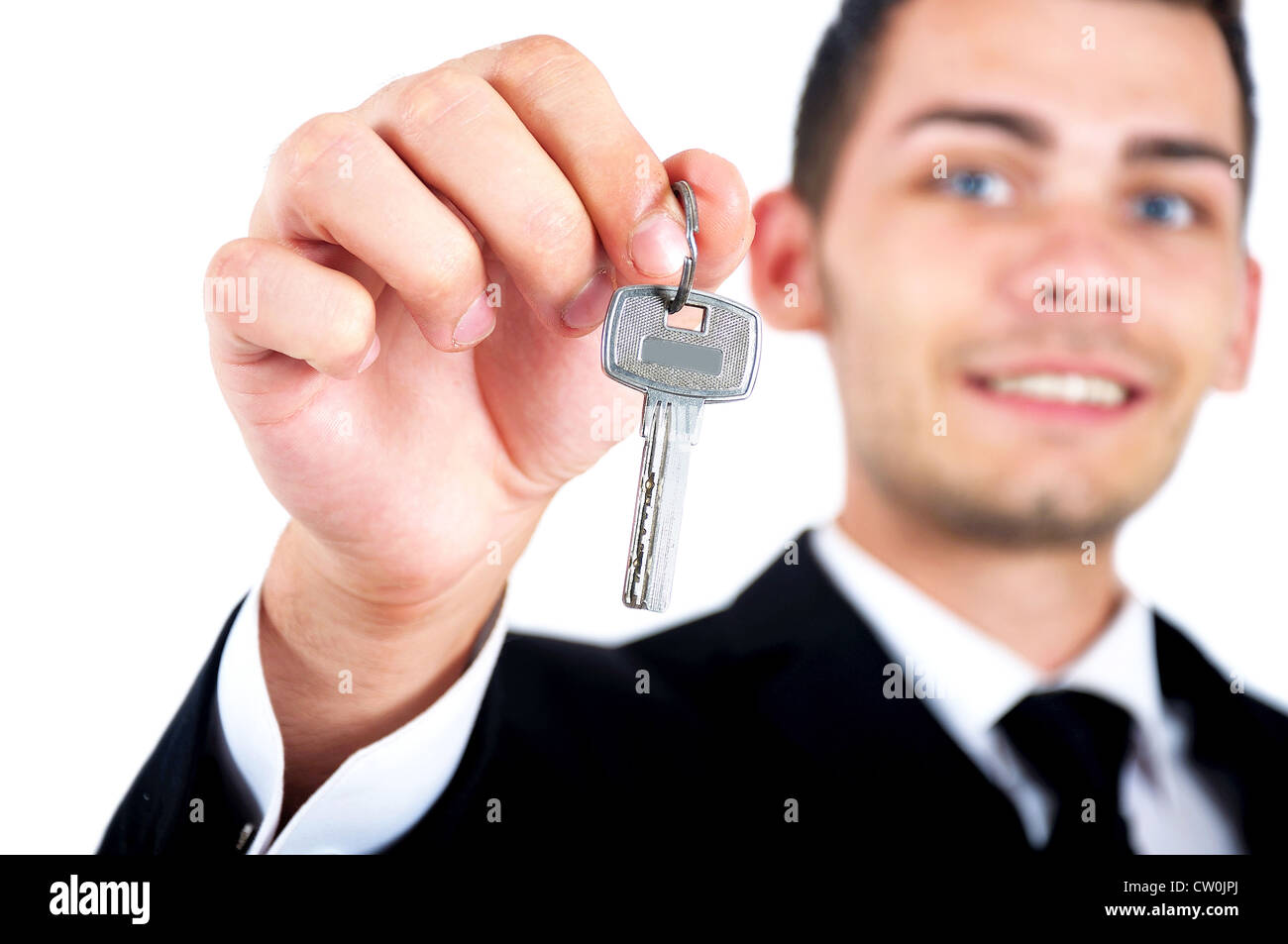 Isolated young business man giving key Stock Photo - Alamy