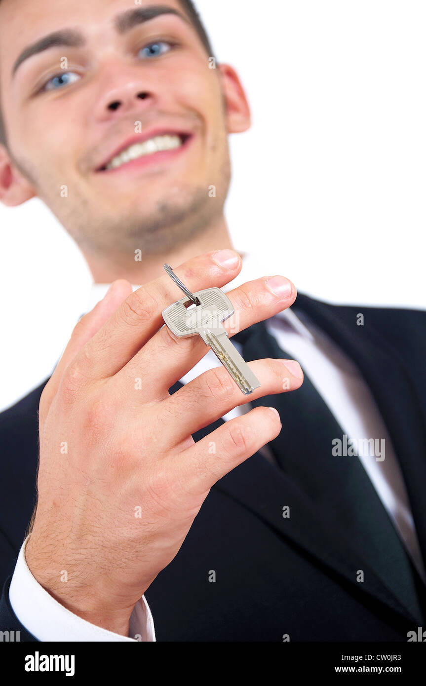 Isolated young business man giving key Stock Photo - Alamy