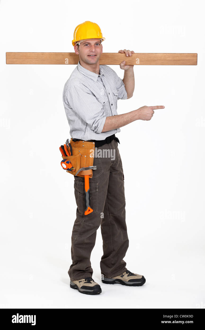 carpenter carrying plank over his shoulder pointing at something Stock ...