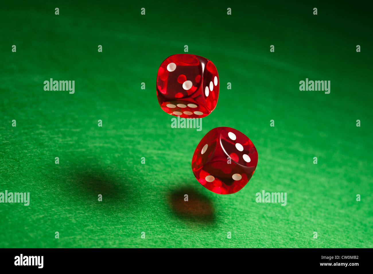 Rolling red dice over green surface Stock Photo - Alamy