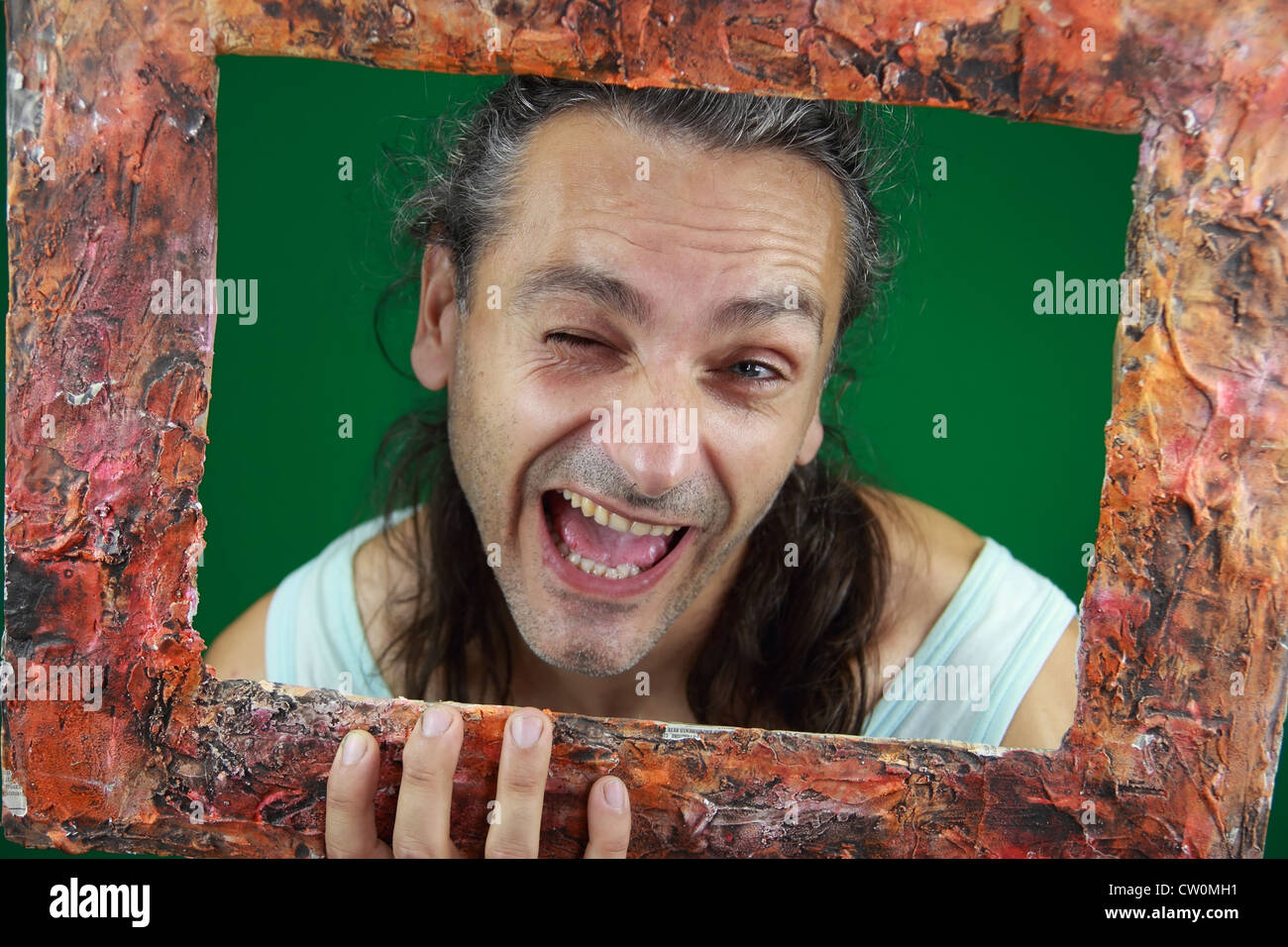 smiling man winking at camera behind a picture frame Stock Photo - Alamy