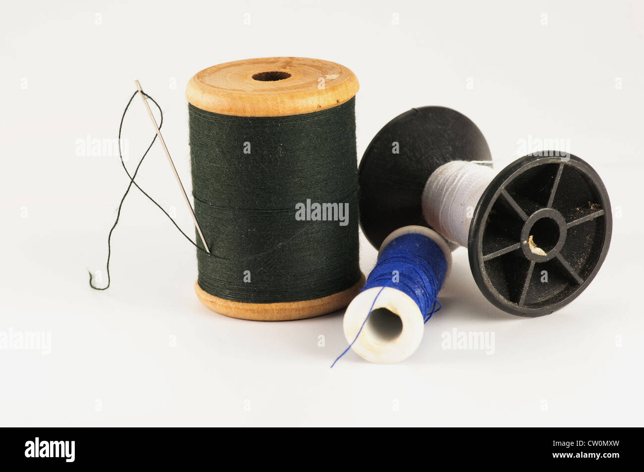 Spool of thread with needle on white background Stock Photo - Alamy