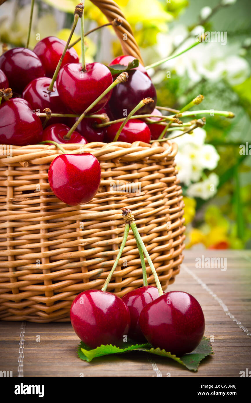 Delicious sweet cherry fruits in wicker basket Stock Photo - Alamy