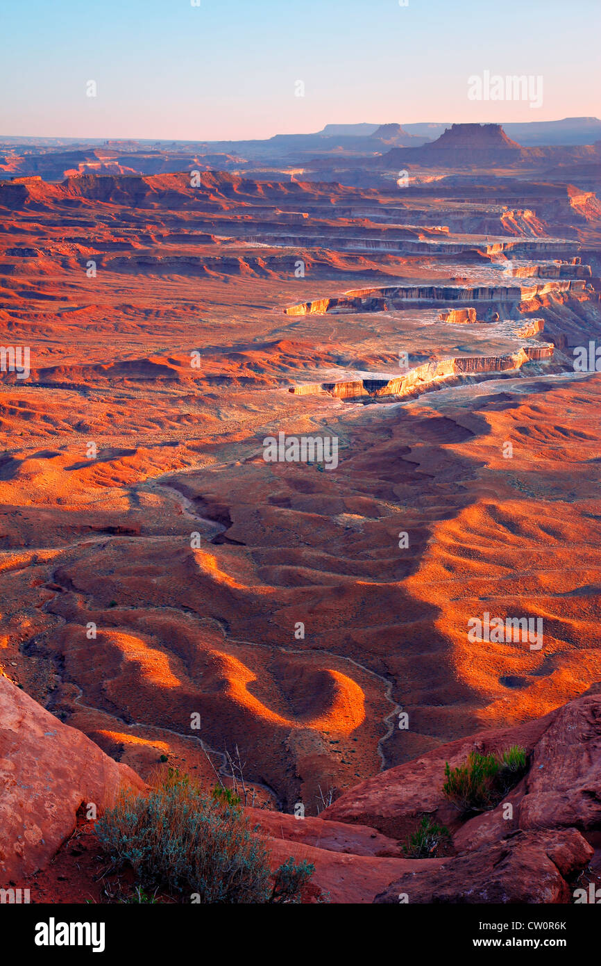 rugged desert terrain in afternoon light cliffs and mesas in background ...