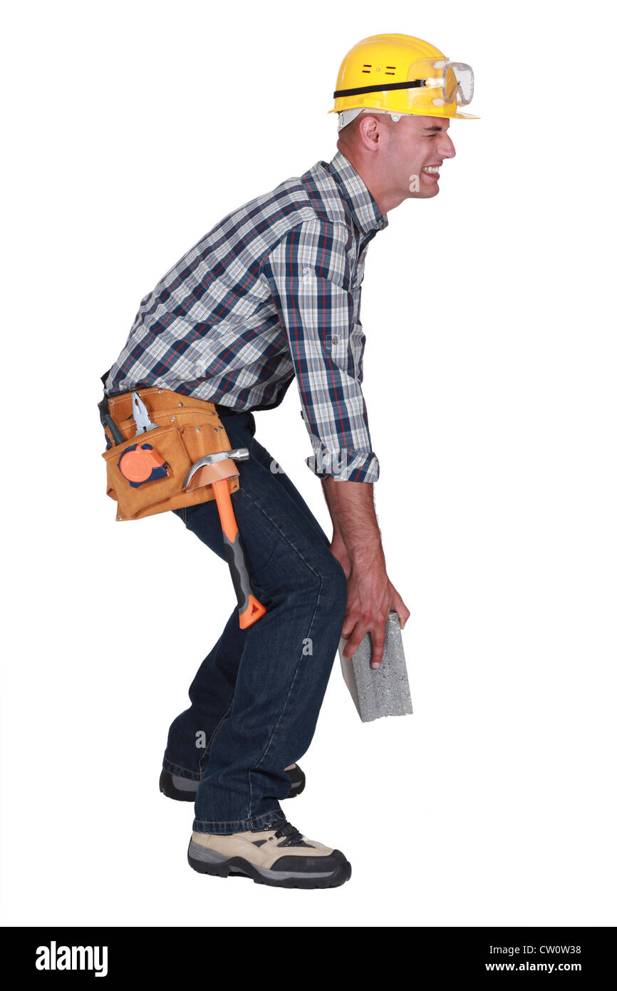 Mason struggling to carry brick Stock Photo - Alamy
