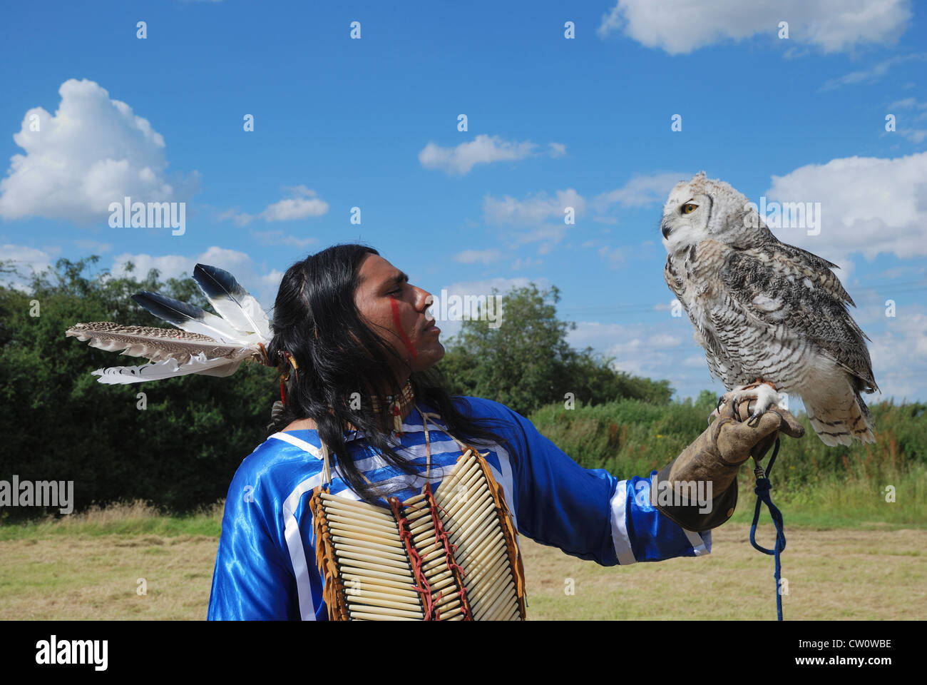 A man posing in traditional Lakota (Sioux) dress with a Great Horned ...