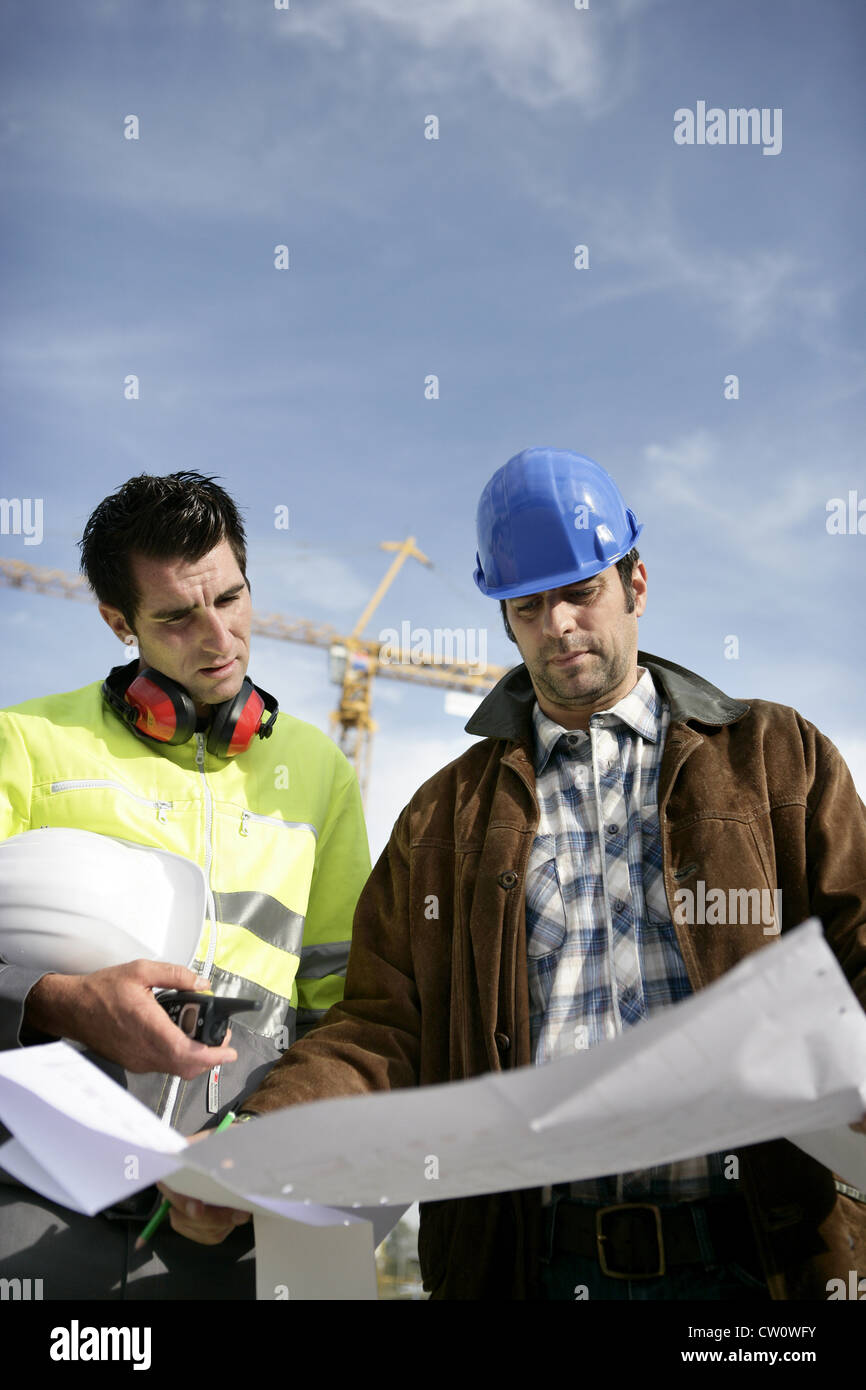 Tradesman and an engineer examining a blueprint Stock Photo - Alamy