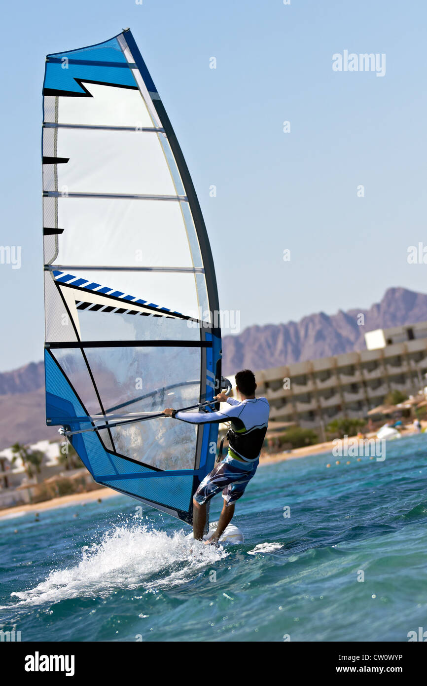 Rear view of a windsurfer passing by Stock Photo - Alamy