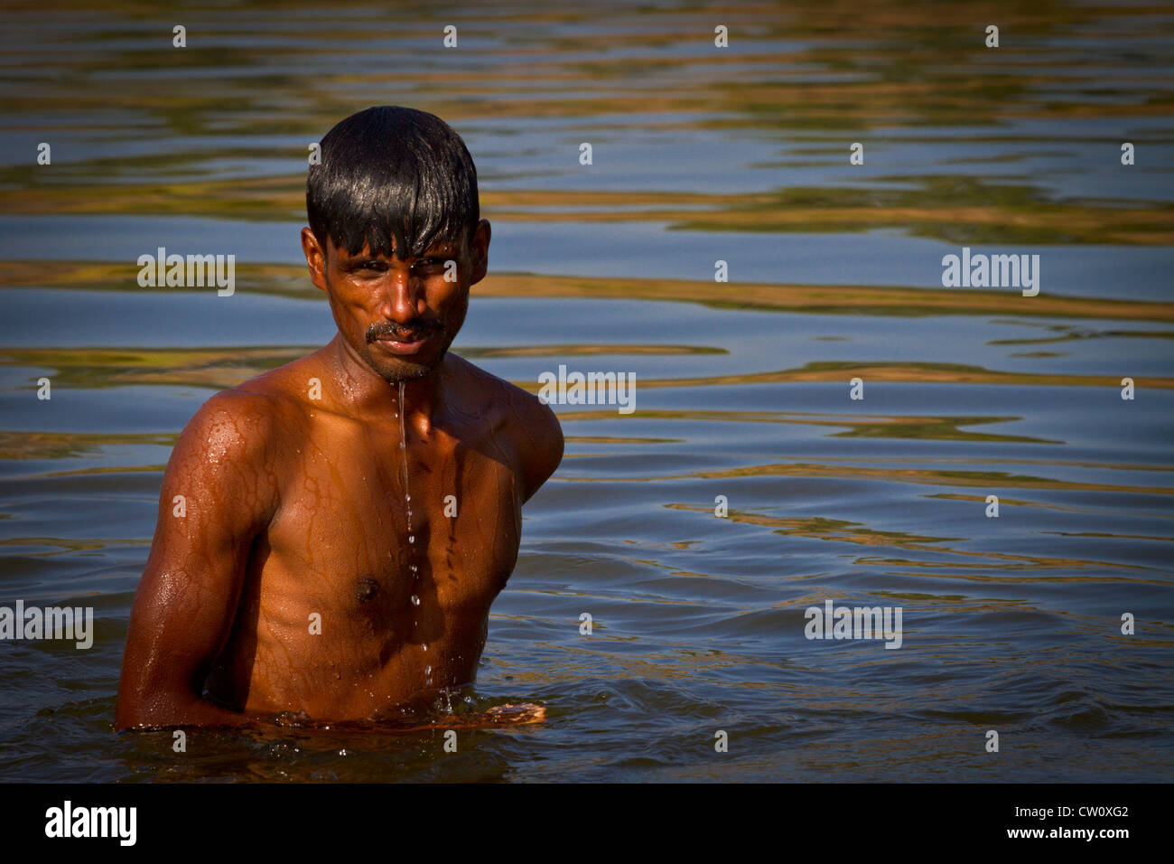 Man takes a early morning dip in the Tungbhadra River, Hampi Stock ...