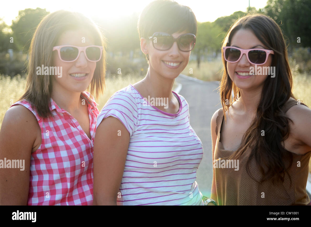Three young friends posing at sunset Stock Photo - Alamy